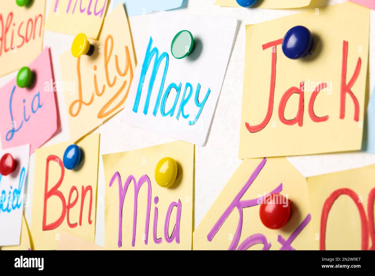 Colorful paper sheets with written different baby names on white ...