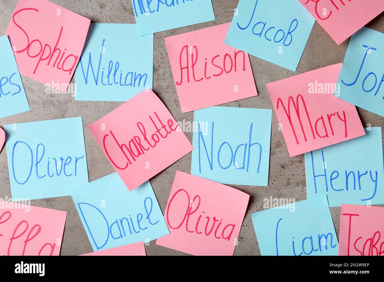 Colorful paper sheets with written different baby names on grey ...
