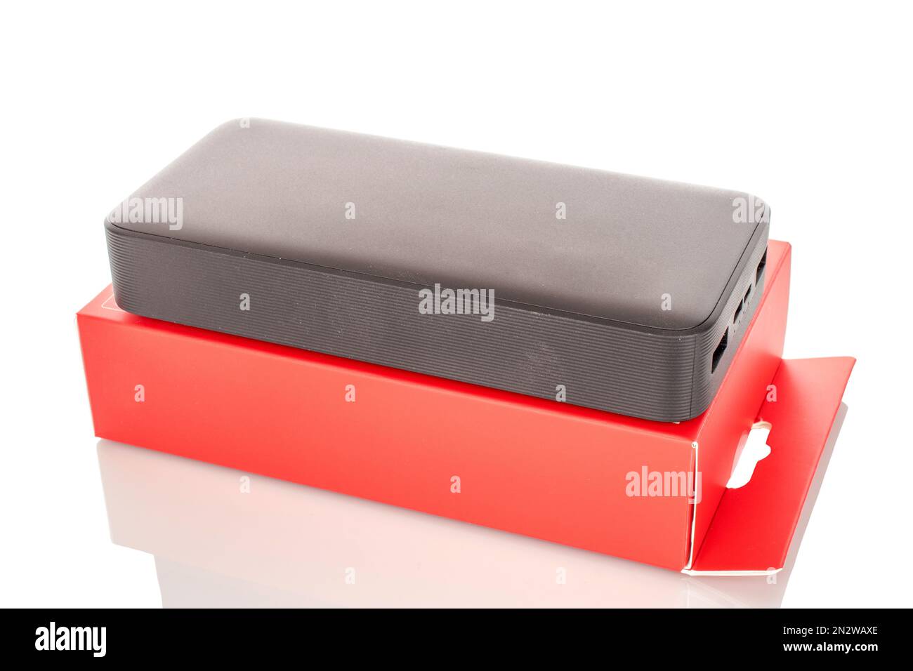 One black portable power bank charger with red paper box, close-up ...
