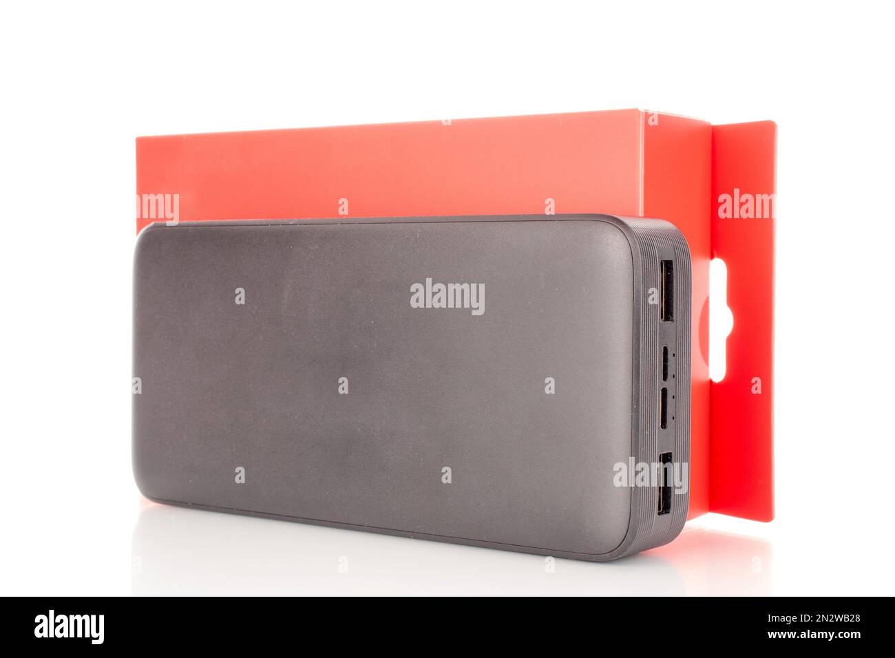 One black portable power bank charger with red paper box, close-up ...