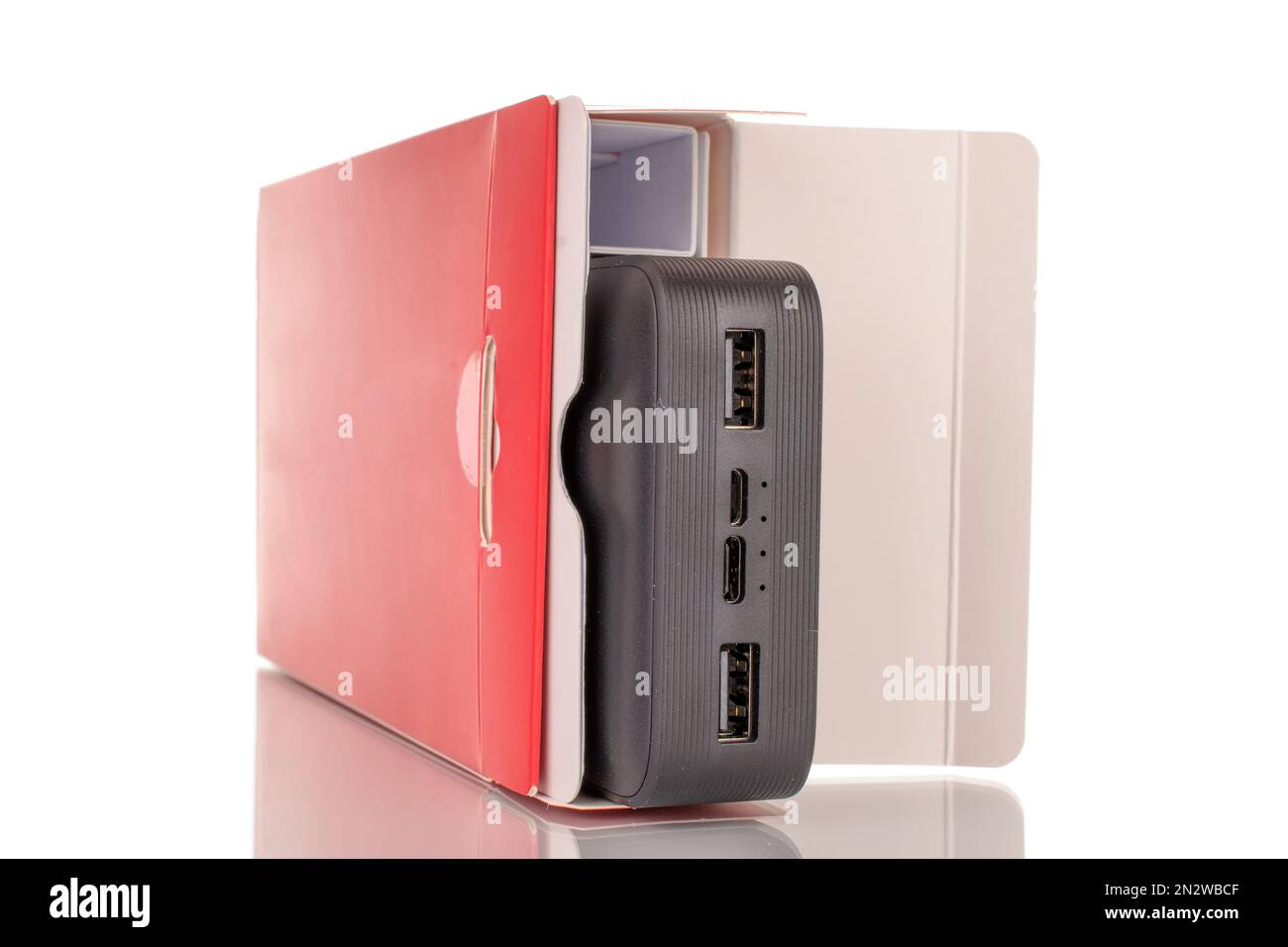 One black portable power bank charger with red paper box, close-up ...