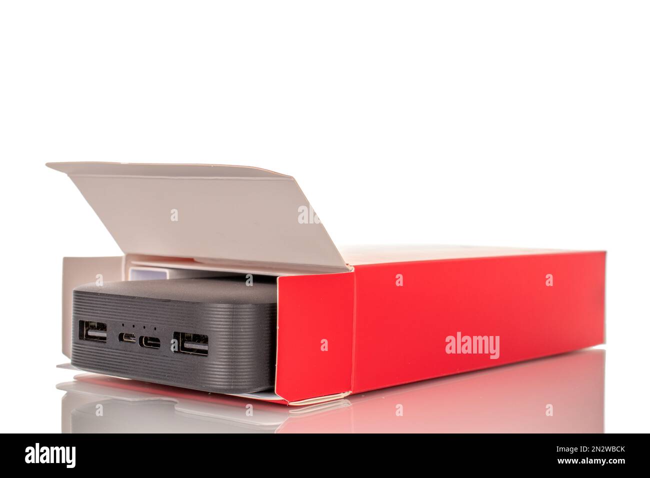 One black portable power bank charger with red paper box, close-up ...