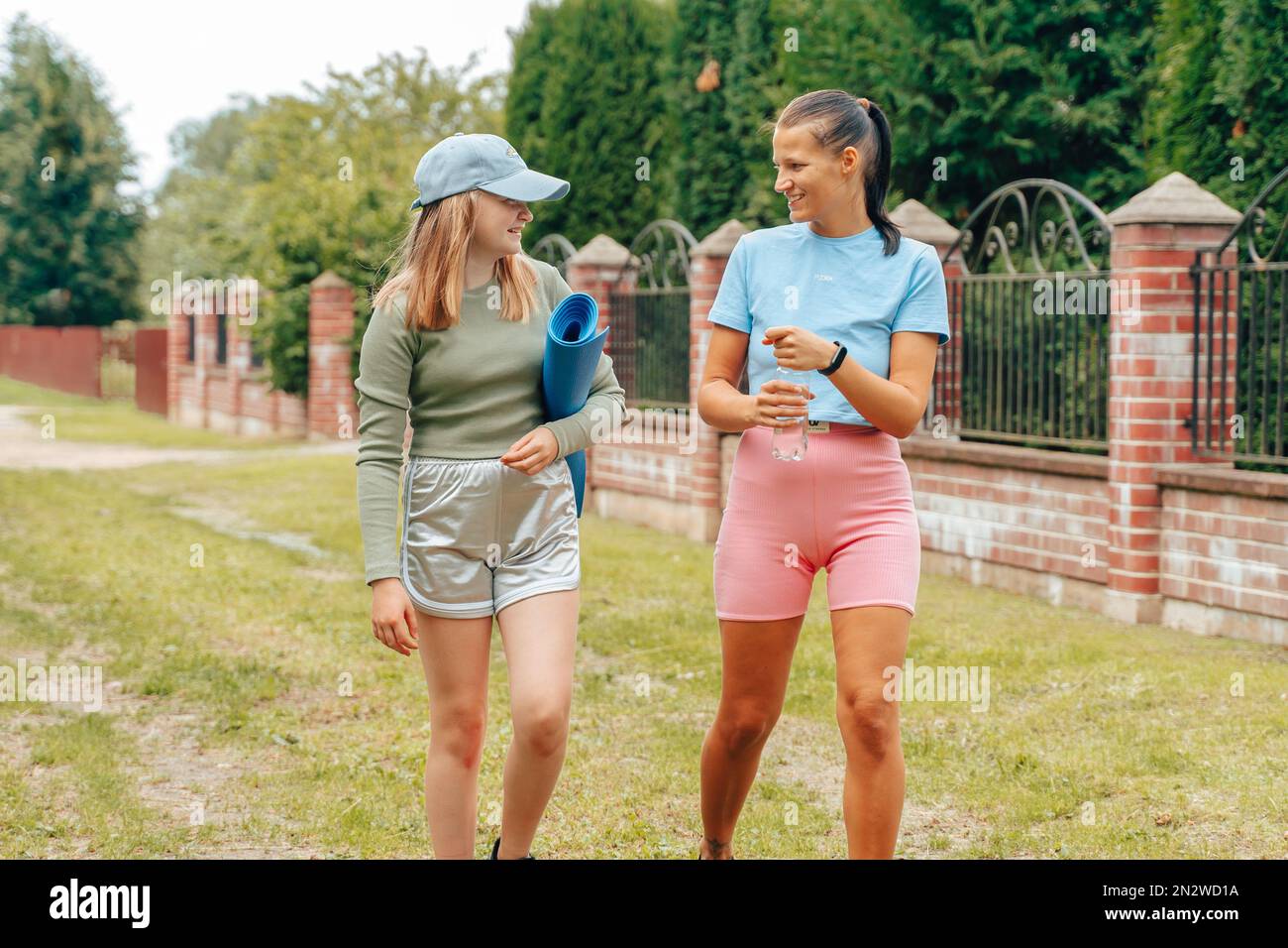 Group of two diverse teen friends walking together chatting after ...