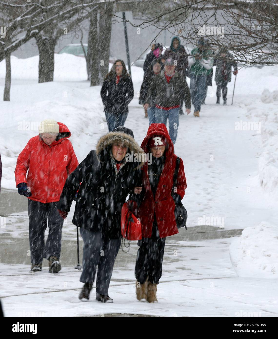 People walk in falling snow Sunday, March 1, 2015, in Piscataway, N.J ...