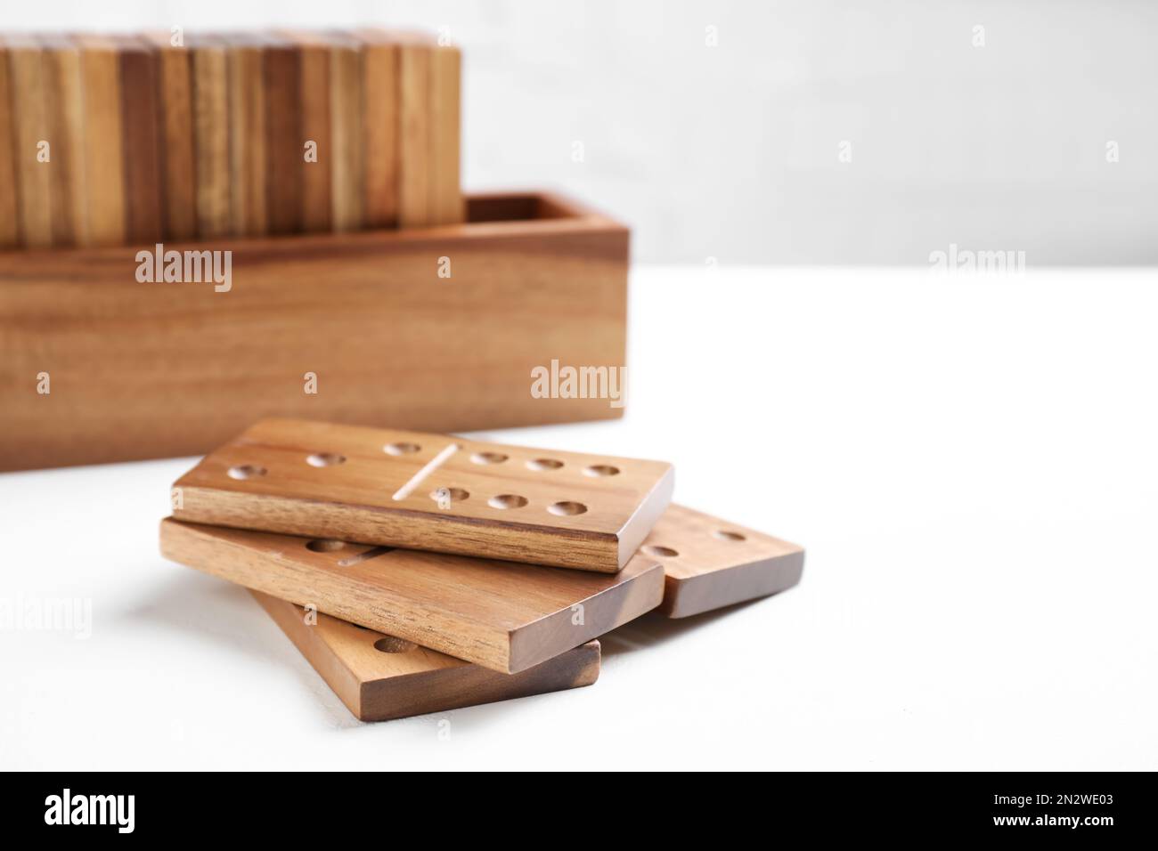 Beautiful wooden dominoes tiles on white table Stock Photo - Alamy