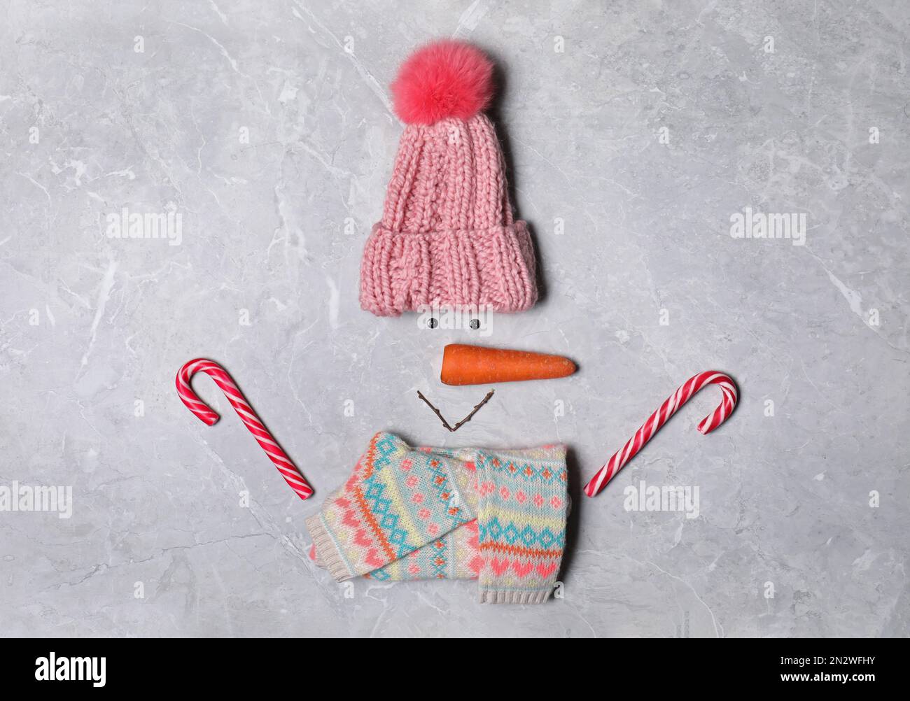 Funny snowman made with different elements on light grey marble ...