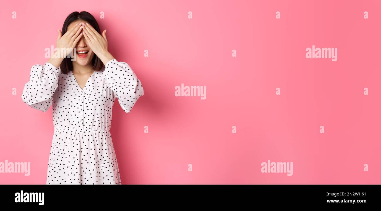 Happy romantic asian girl waiting for surprise, close eyes and smiling ...