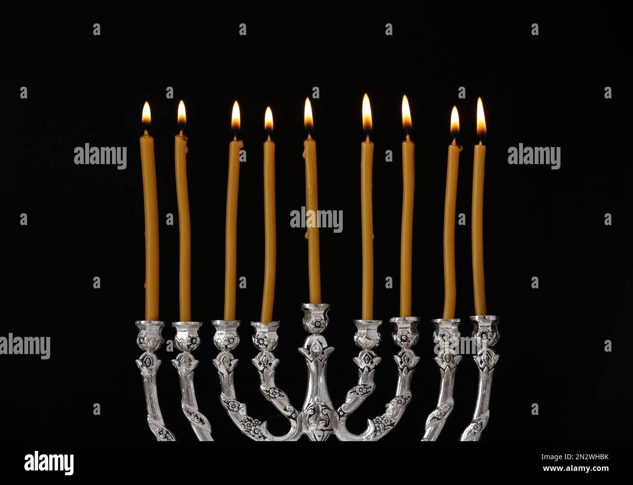 Silver menorah with burning candles against black background. Hanukkah ...