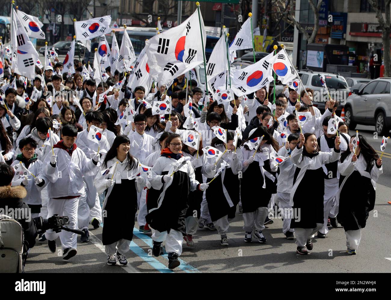 South Koreans with their national flags march on a street during a ...