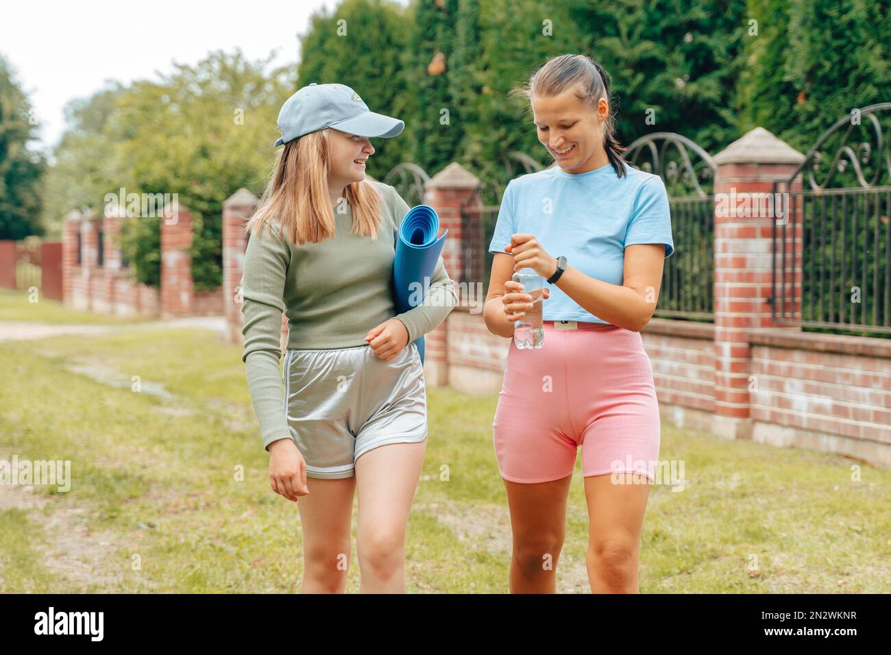 Group of two diverse teen friends walking together chatting after ...