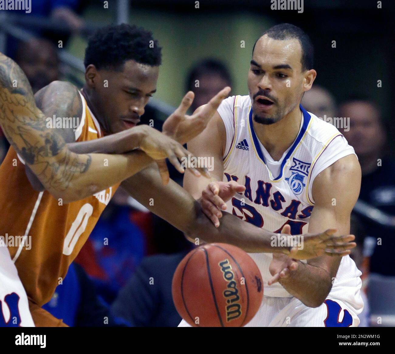 Kansas forward Perry Ellis (34) reaches for the ball with Texas guard ...