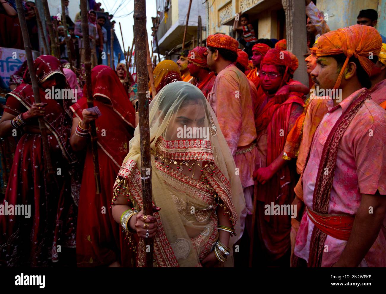 Indian Hindu women from Nandgaon village with their wooden sticks wait ...