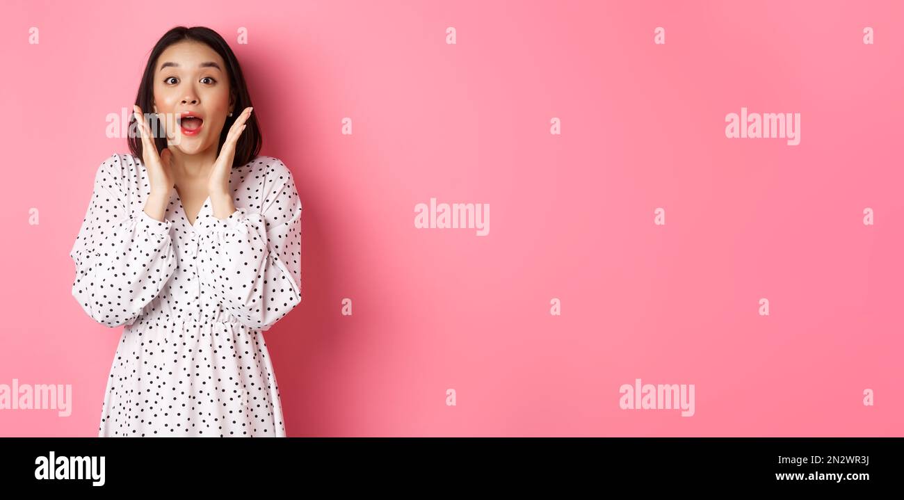 Image of surprised korean girl in dress, female model staring at camera ...