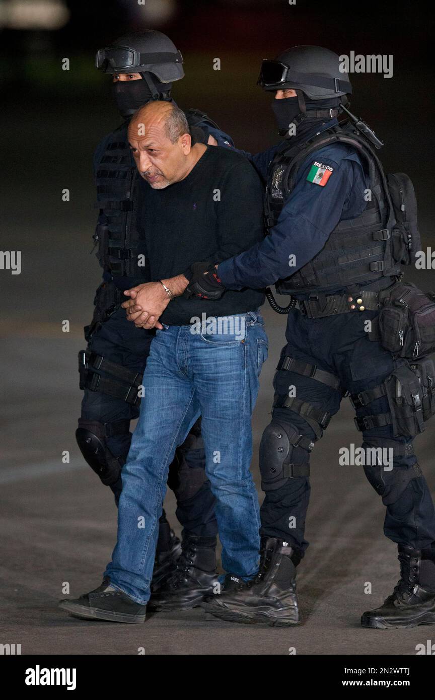 Federal police escort who they identify as Servando "La Tuta" Gomez ...