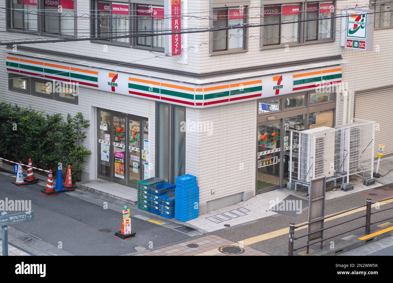 A bright storefront shot of a busy 711, a popular Japanese convenience ...