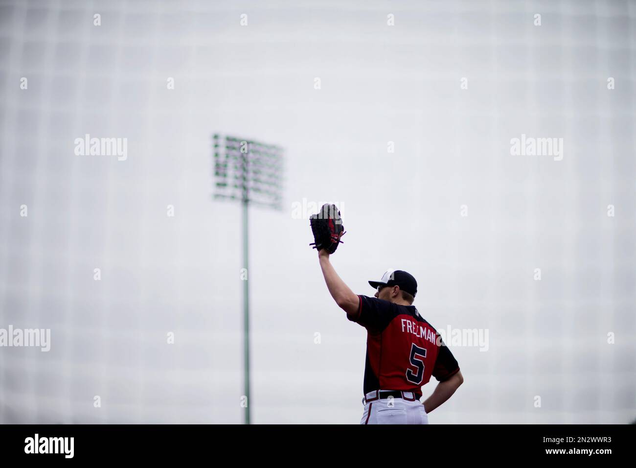 Atlanta Braves' Freddie Freeman is seen through netting as he fields ...