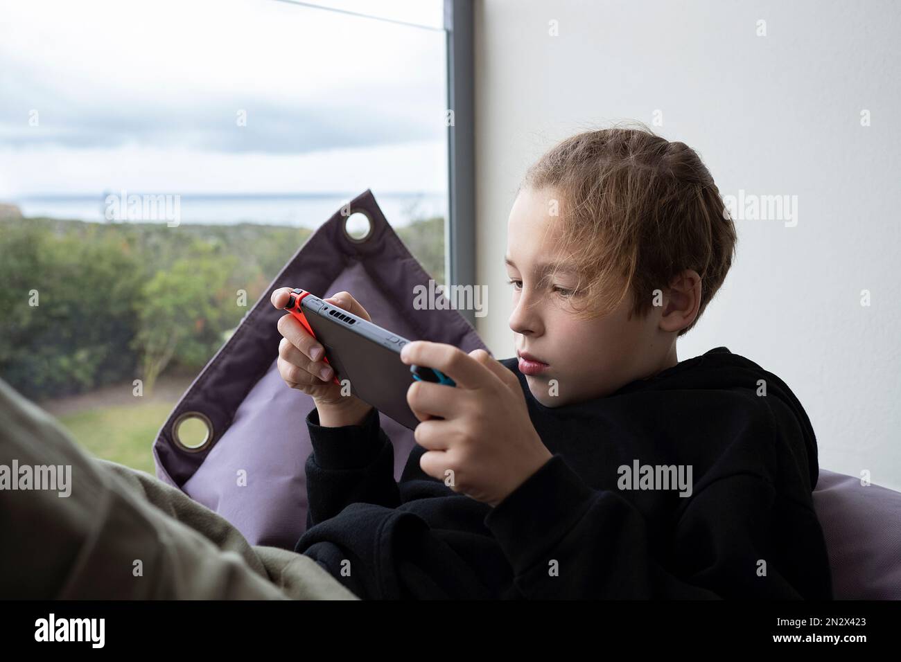 Boy teenager being attracted with game on handheld console Stock Photo ...