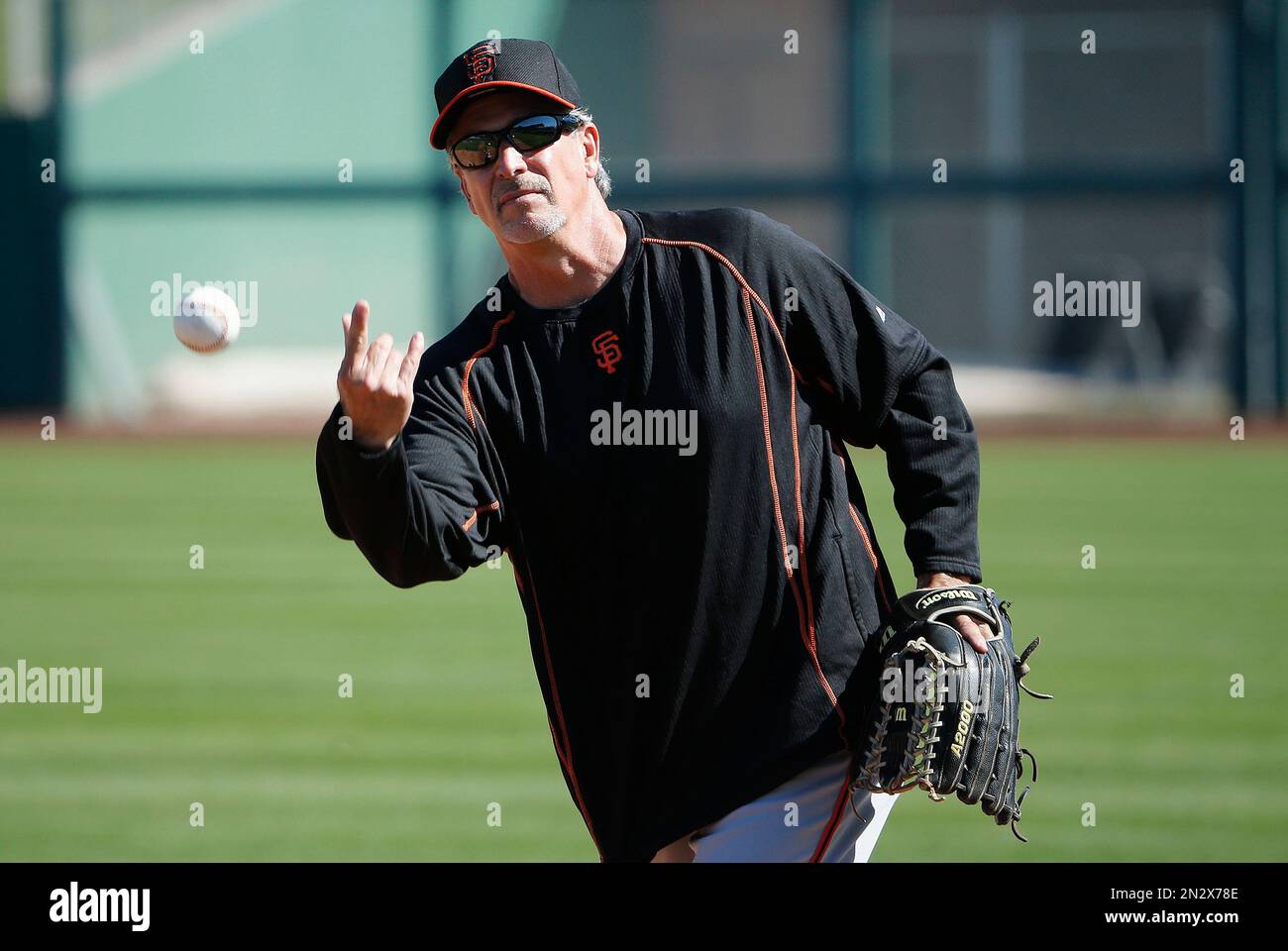 San Francisco Giants bench coach Ron Wotus tosses the ball back to ...