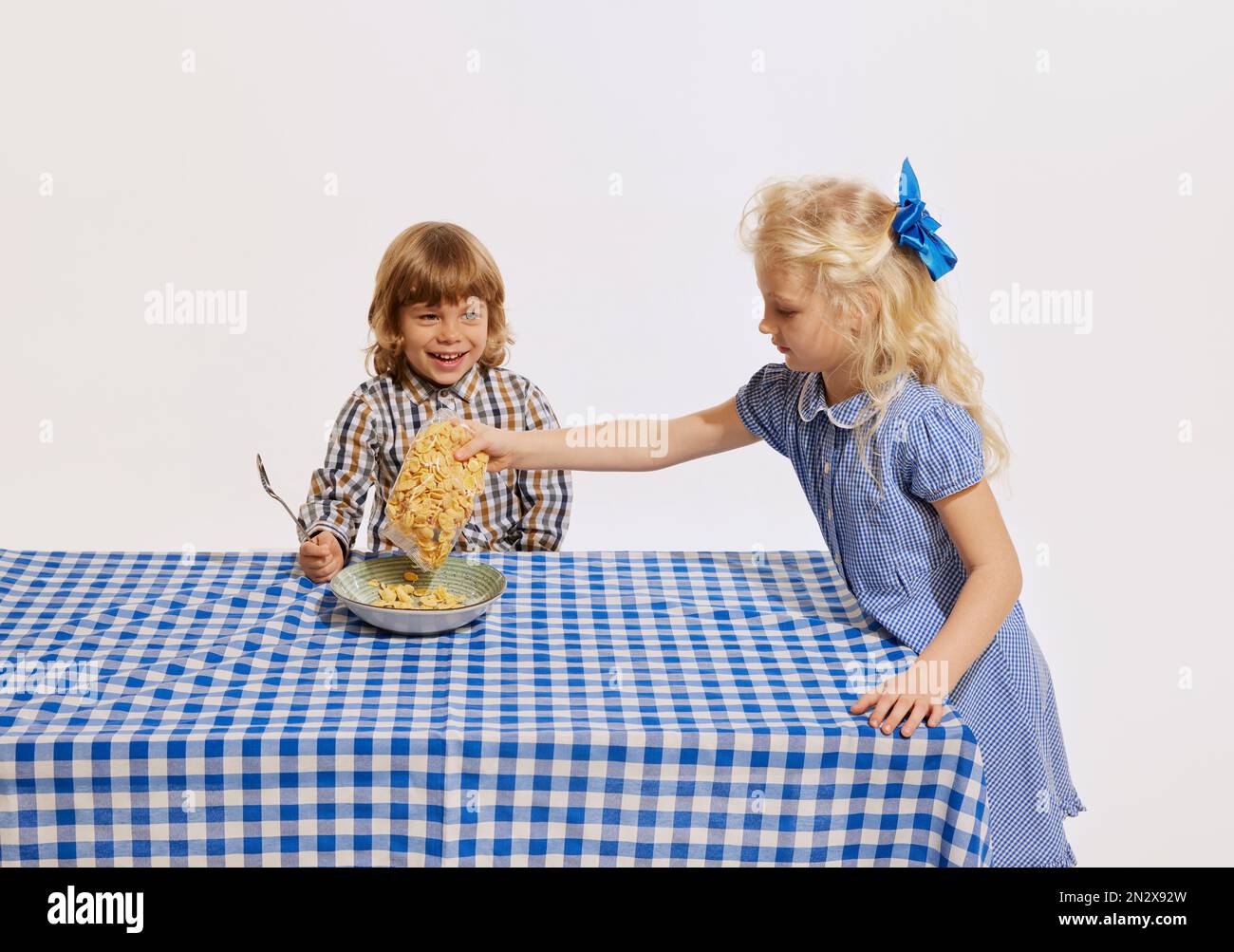 Cute children, kids playing, having fun, tasting corn flakes together ...
