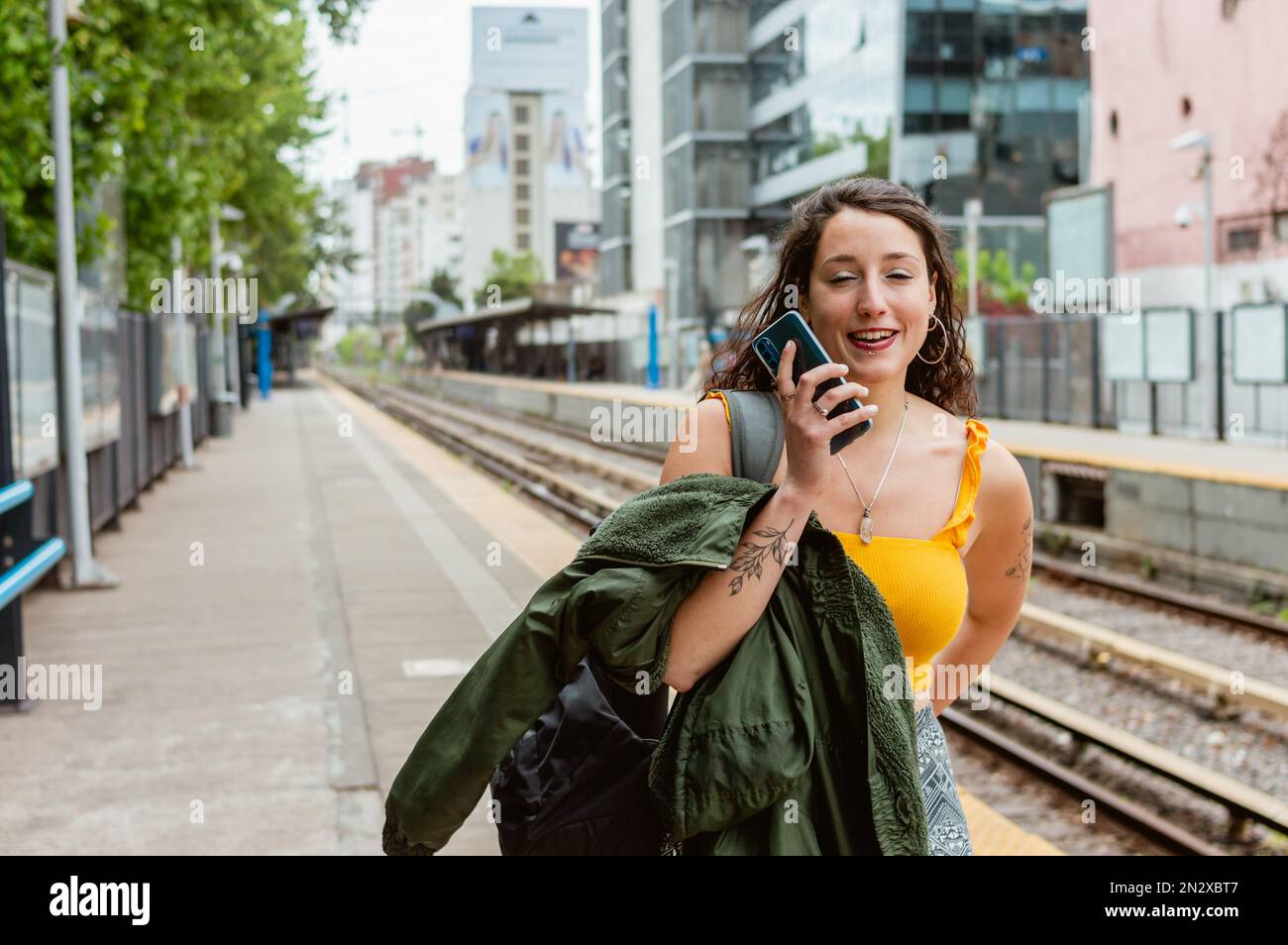 Young Latina Woman Of Argentinian Ethnicity Is Walking Along The Train Platform Towards The