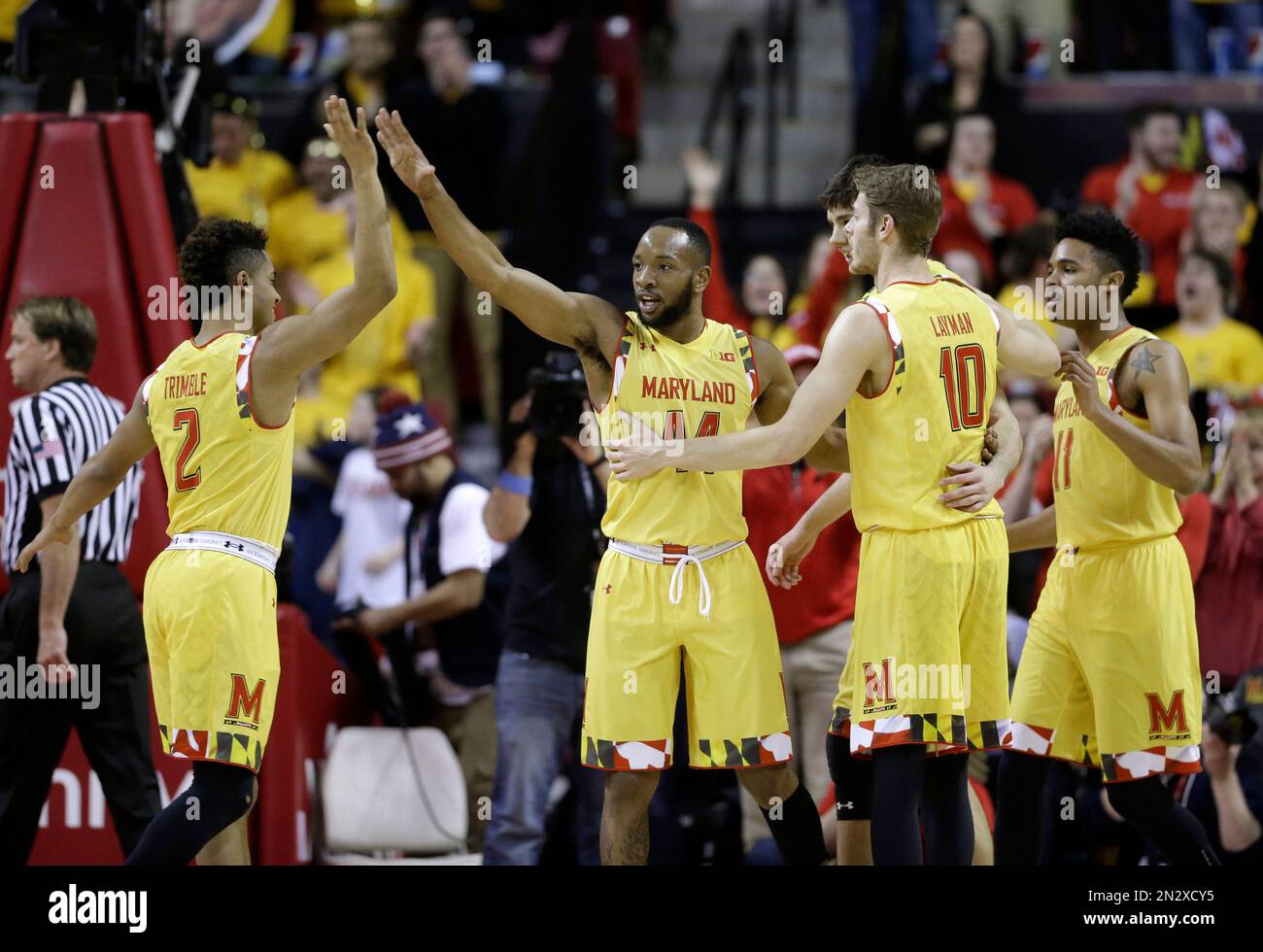 Maryland guard/forward Dez Wells, center, high-fives teammate Melo ...