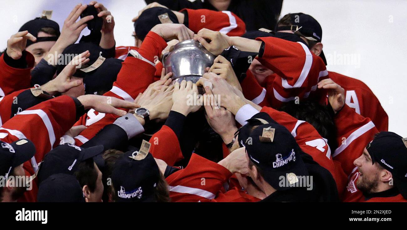 Boston University players reach for the Beanpot trophy after a win ...