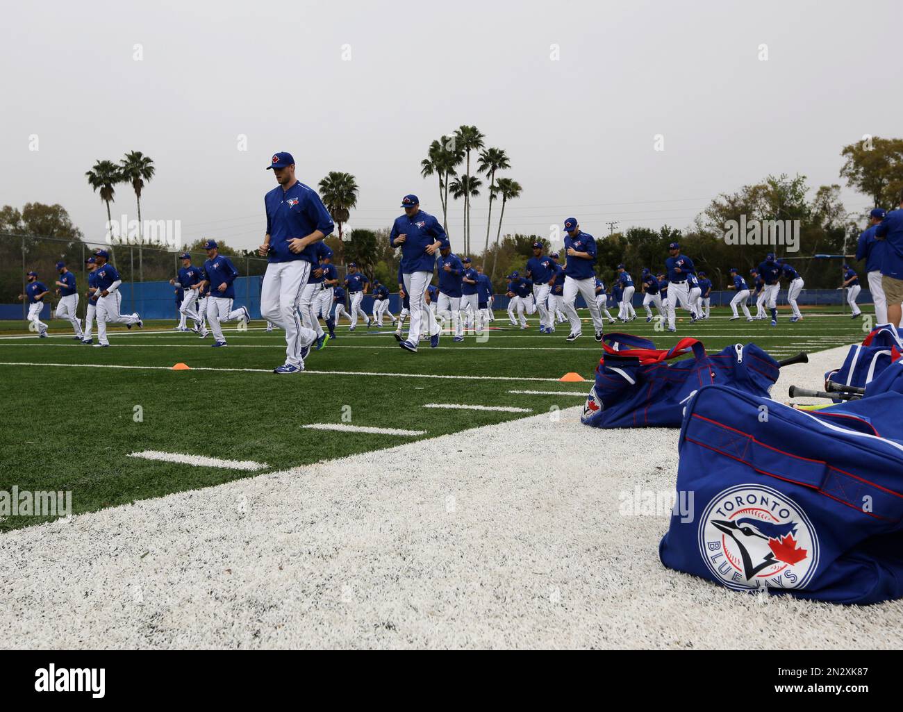 Toronto Blue Jays players do running and stretching exercises during a ...