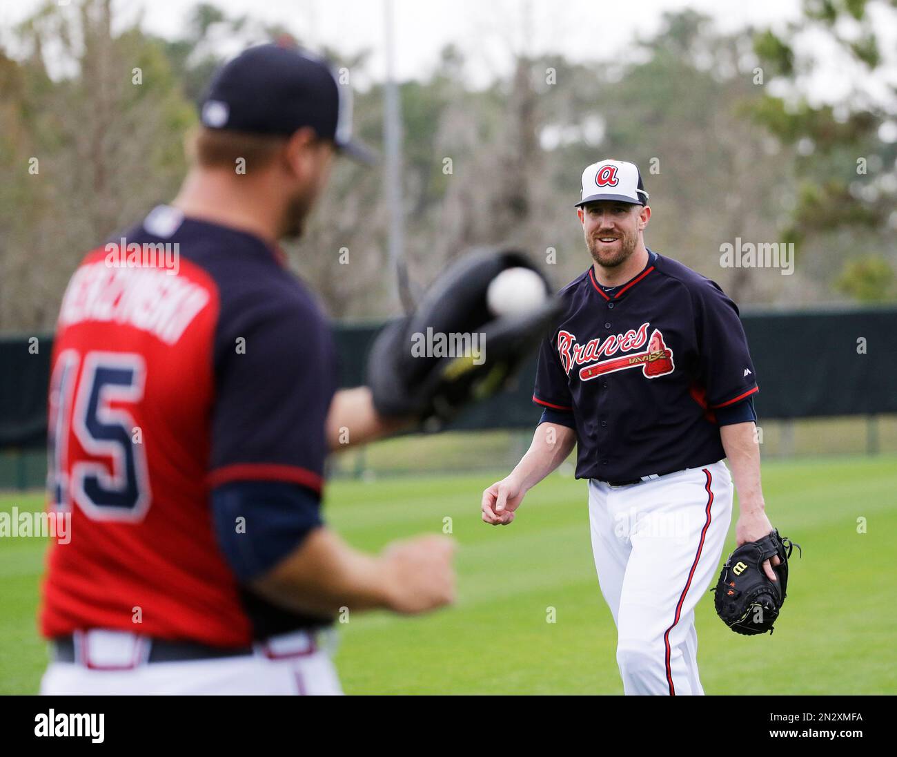 Atlanta Braves' John Buck, right, tosses a ball with fellow catcher A.J ...