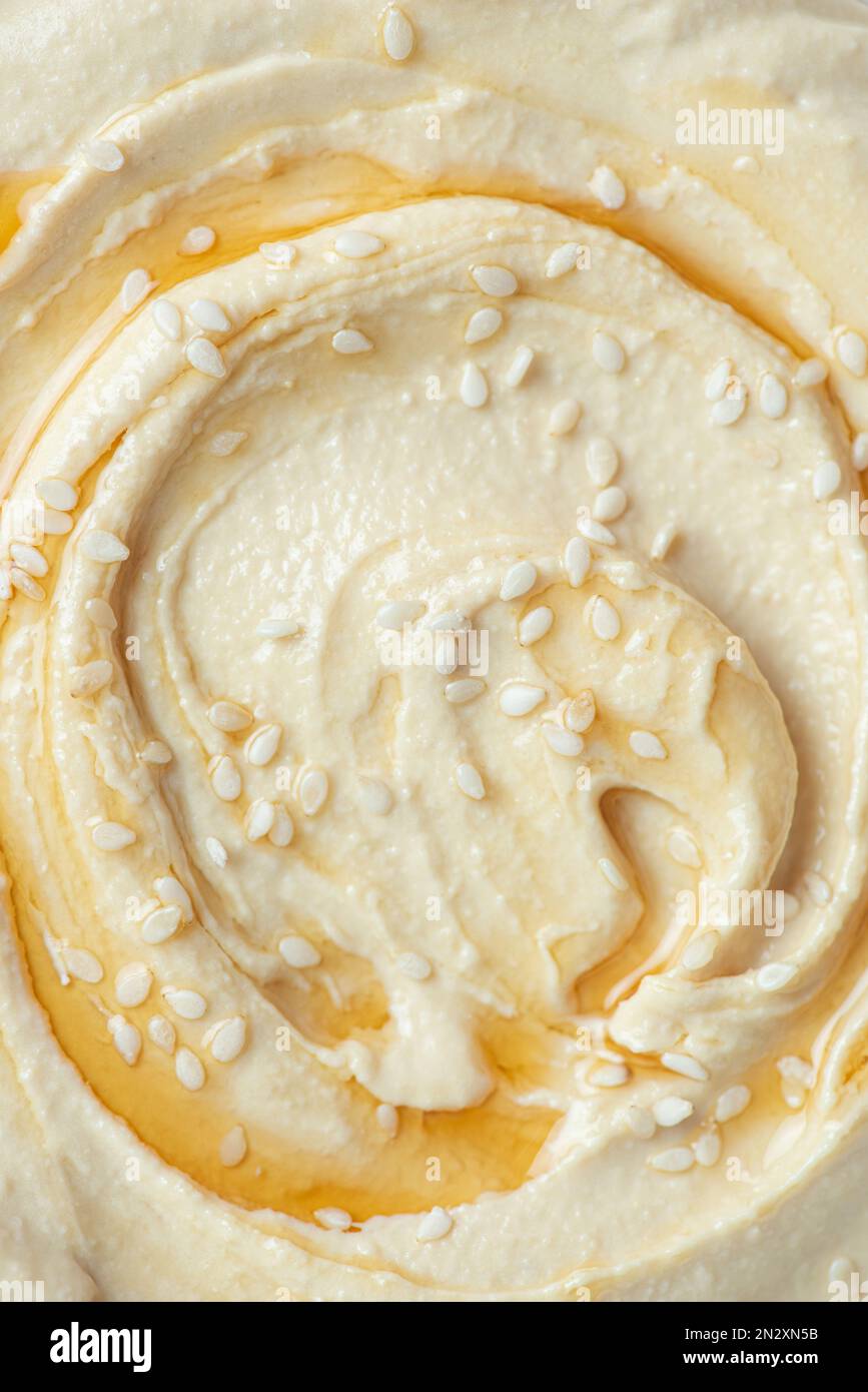Macro texture of cooked chickpea hummus with sesame seeds Stock Photo ...