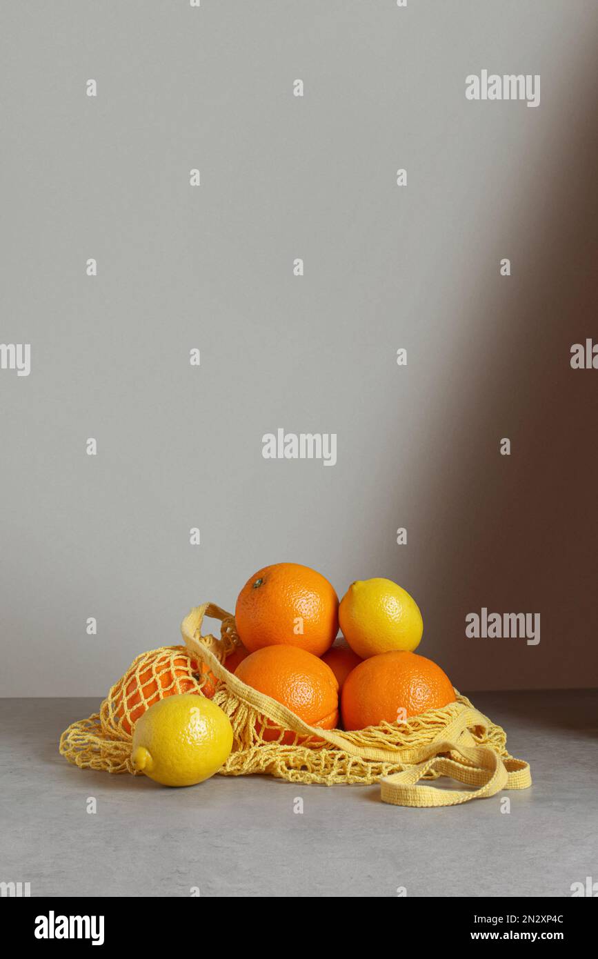 zero waste packaging. Oranges and lemons in a string bag on the table ...