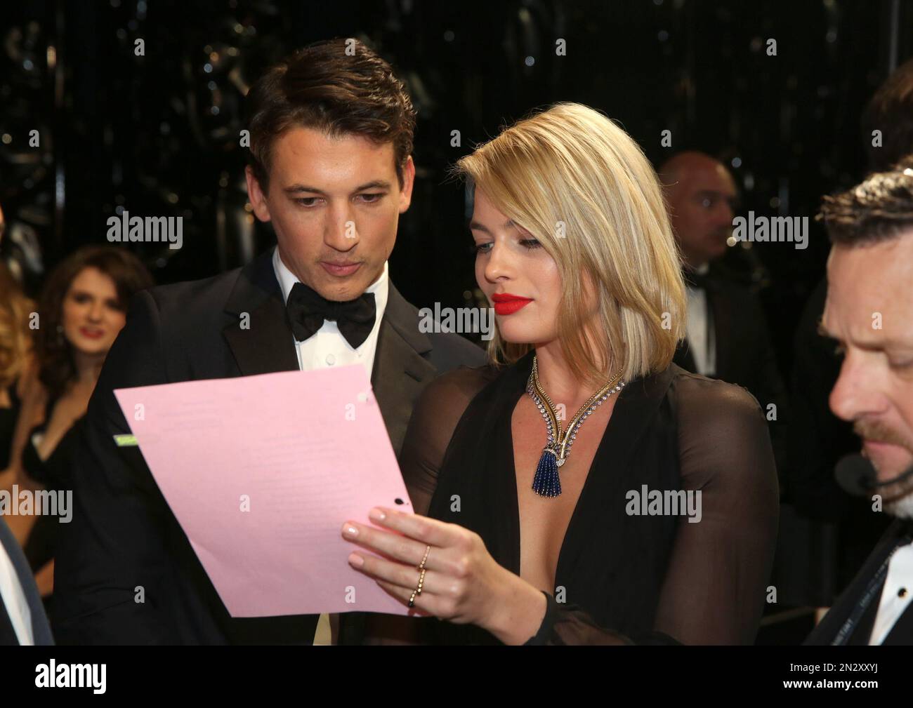 Miles Teller, left, and Margot Robbie are seen backstage at the Oscars ...