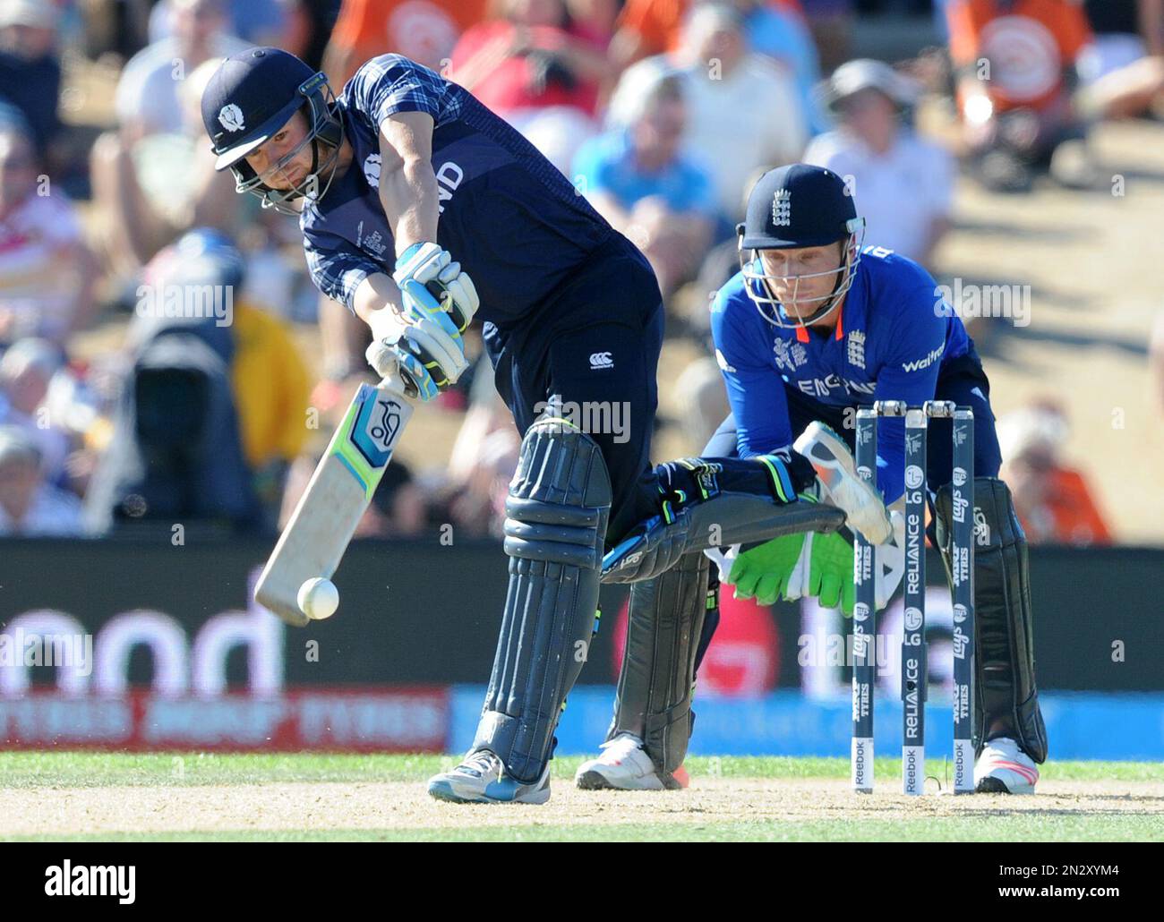 Scotland's Matt Cross hits the ball as England wicketkeeper Jos Buttler ...