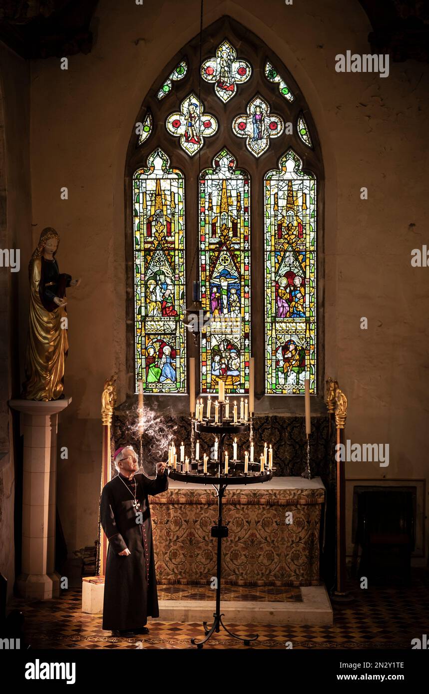 The Rt Reverend Glyn Webster lights a candle in front of the newly ...