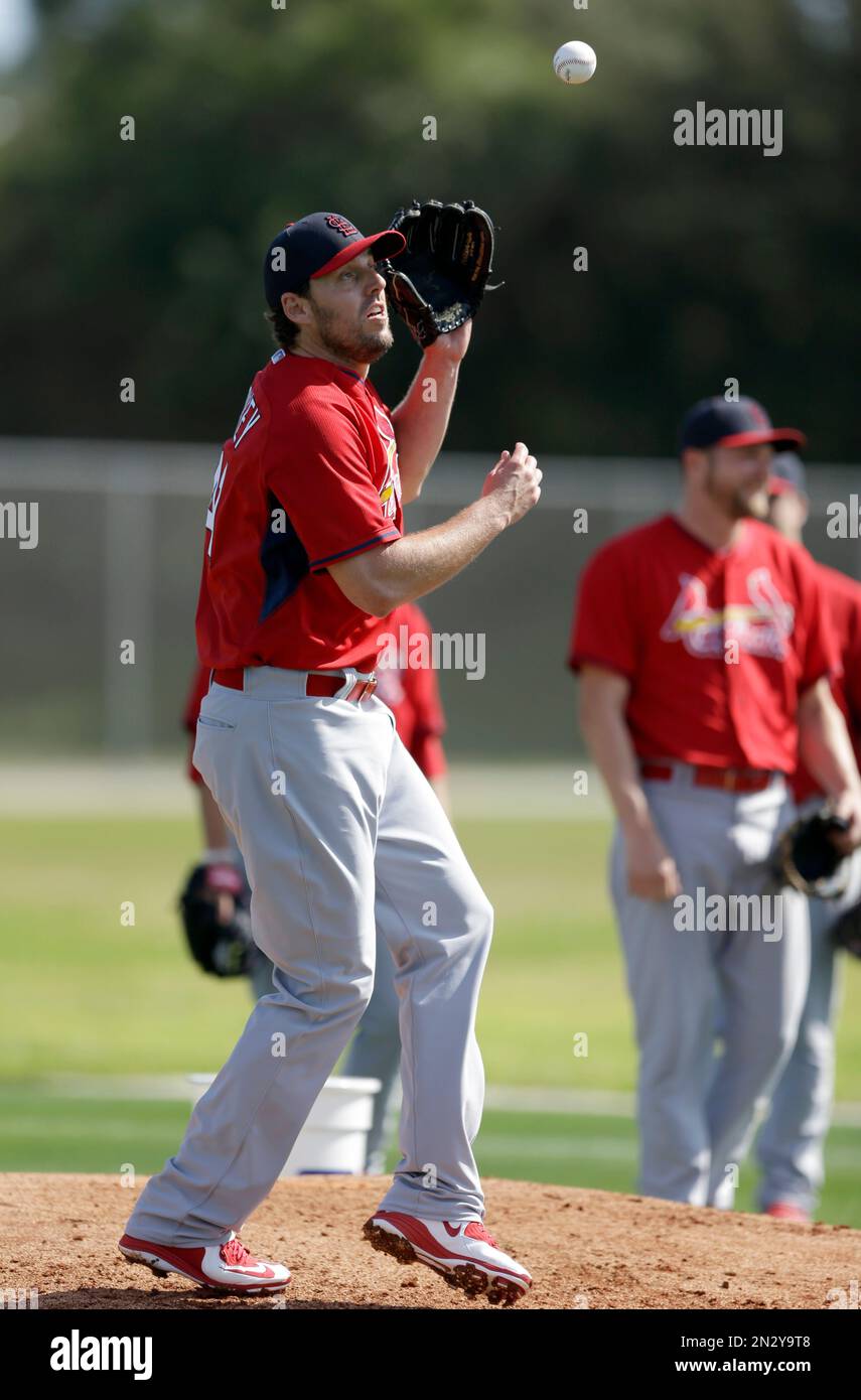 St. Louis Cardinals pitcher John Lackey stops a ball hit back to him ...