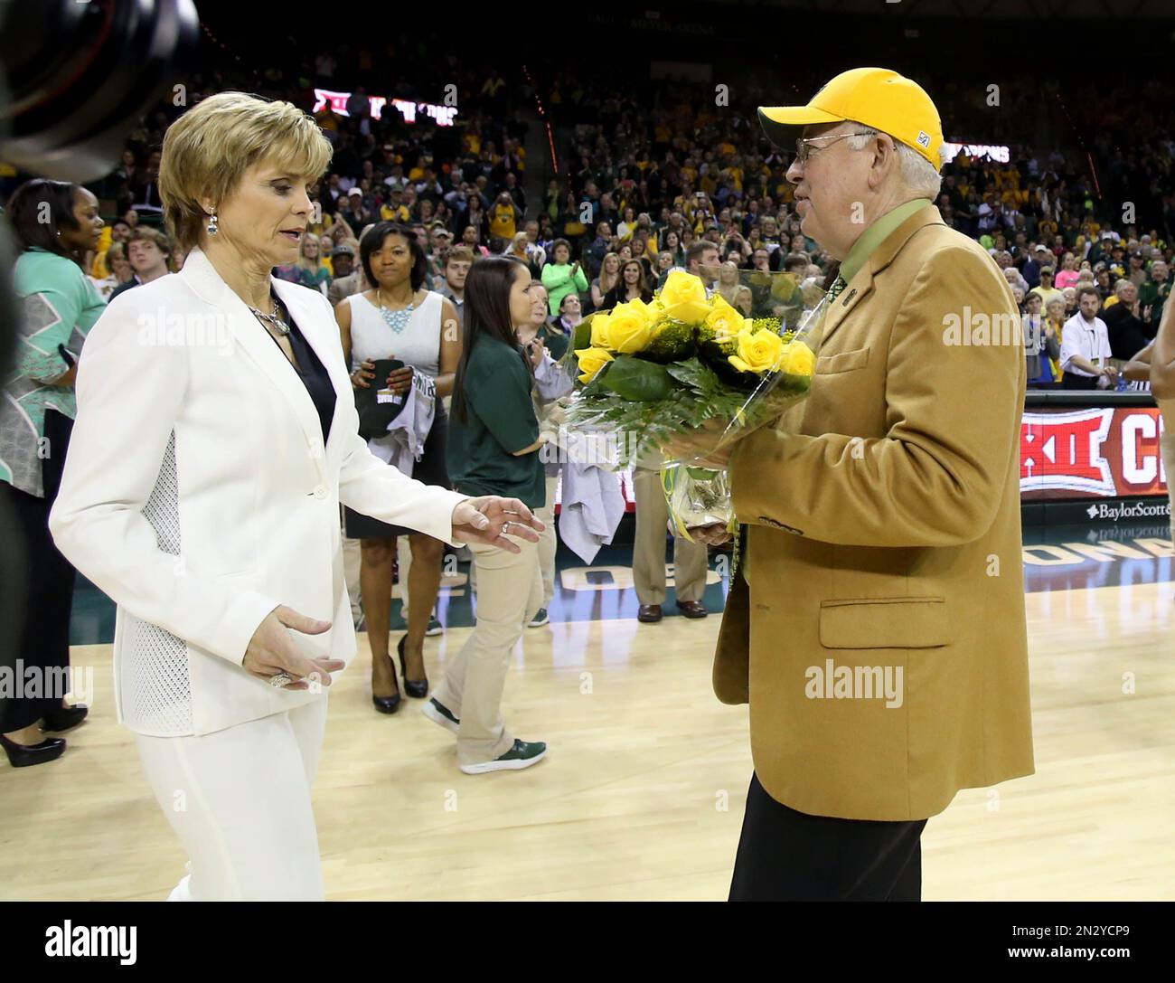 Baylor head women's basketball coach Kim Mulkey, left, is handed roses ...