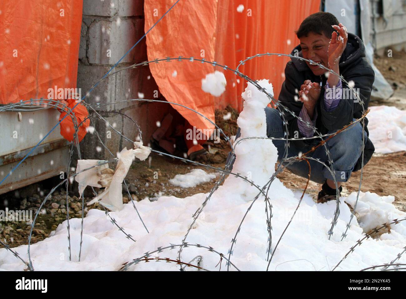 A Syrian Refugee boy plays in the snow after recent stormy weather and ...