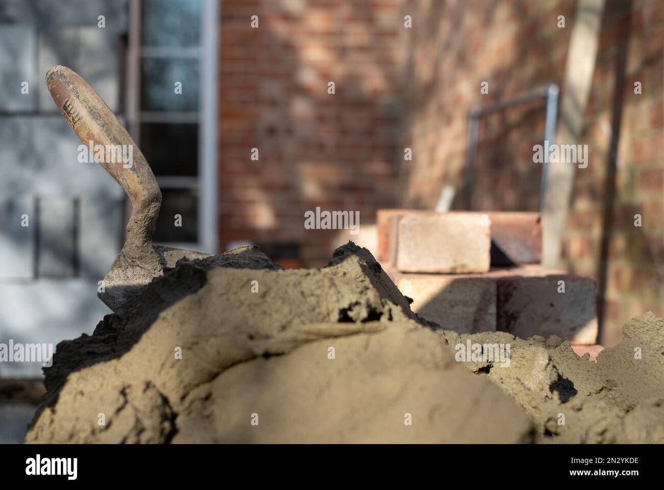 Building site: trowel, bricks and mortar for brickwork, part of a ...