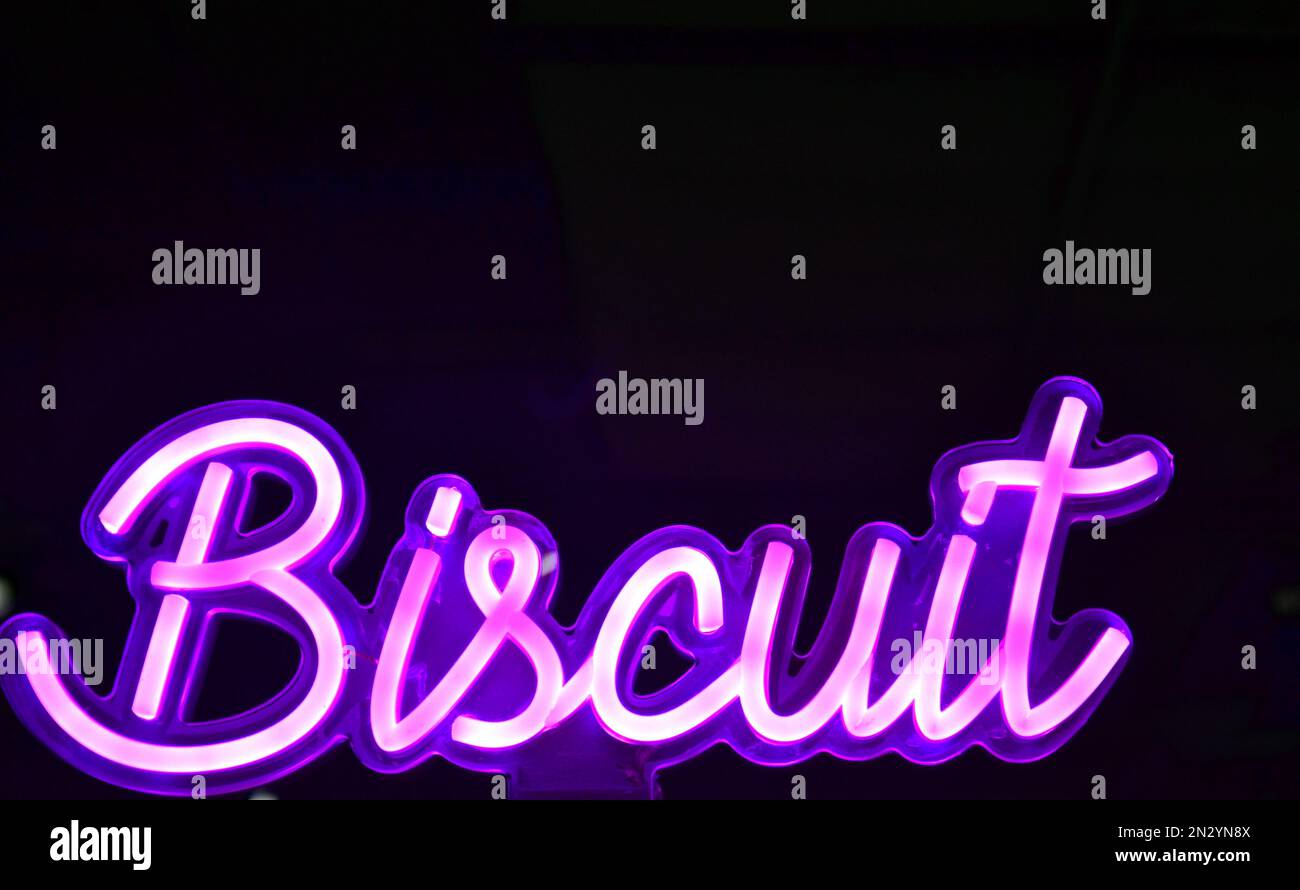 Illuminated sign saying: 'Biscuit' on a dark background in a retail ...