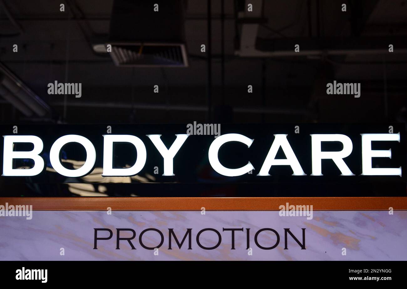 Illuminated sign saying: 'Body Care Promotion' on a dark background in ...