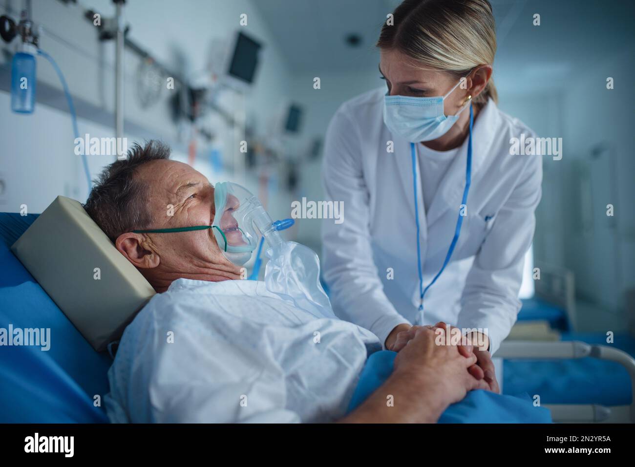 Young woman doctor talking to elderly patient with oxygen mask Stock ...