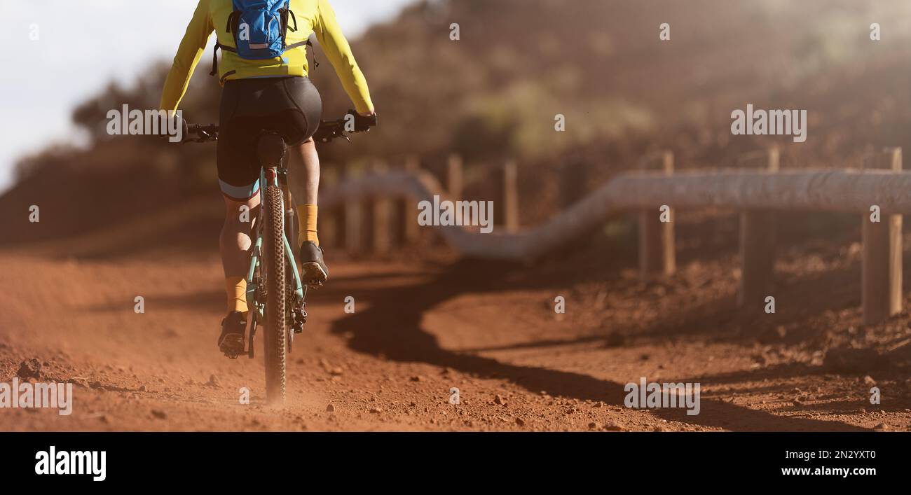 Mountain biker riding on bike singletrack trail, back view of mountain ...