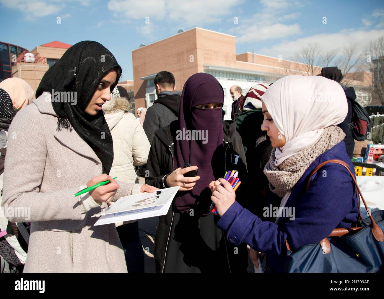 Sarah Javid, left, signs a condolence book at Queens College in New ...
