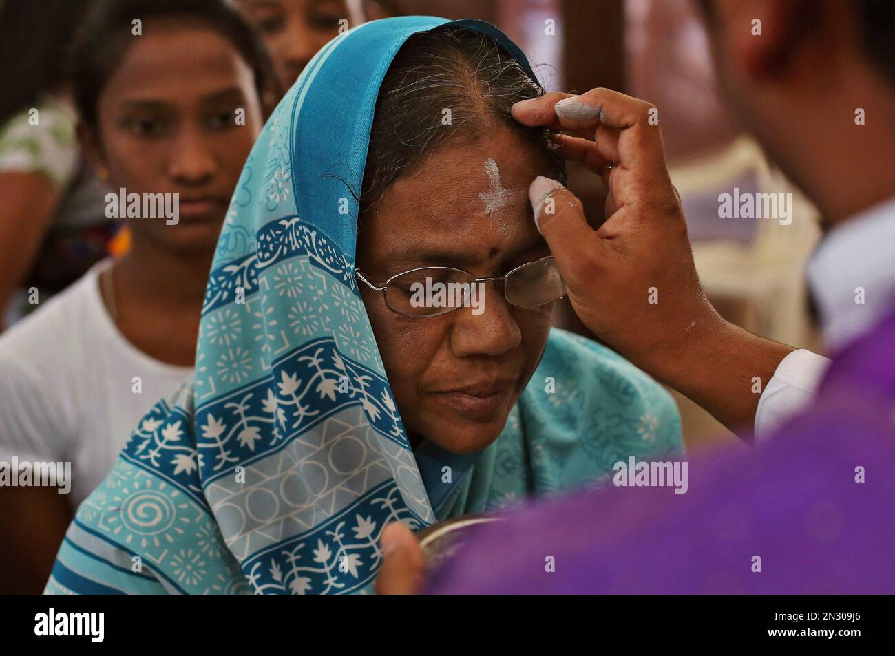 An Indian Catholic priest marks cross symbol on the forehead of ...