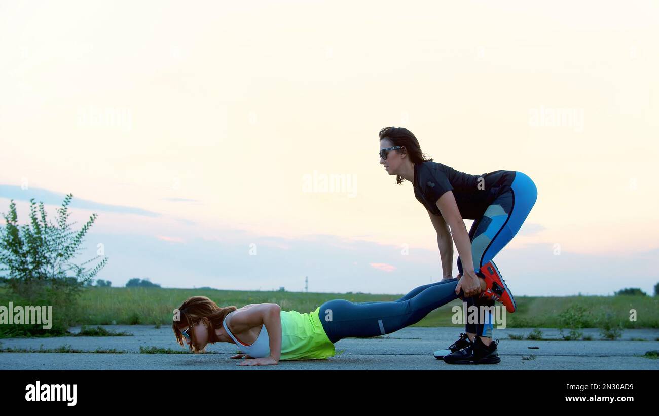 Beautiful, athletic, young women in sunglasses, in tights, perform ...