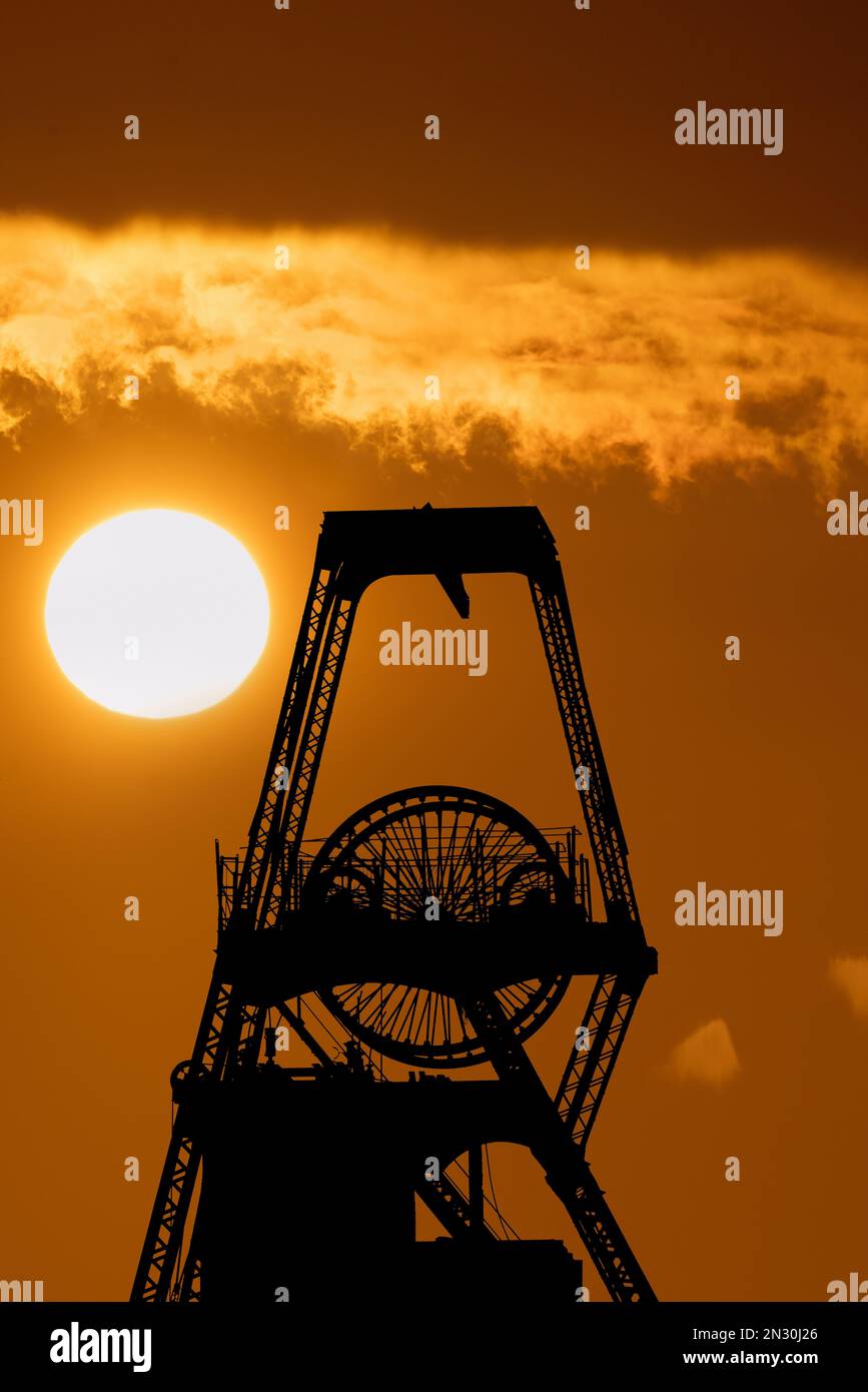 Pit headstock at sunset. Colliery winding wheel at sunset. Coal mining ...