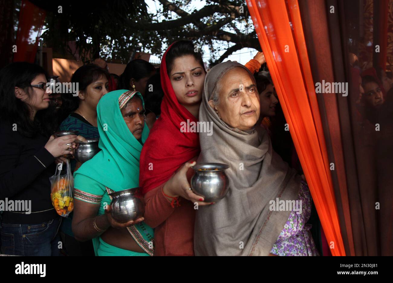 Hindu devotees wait their turn to offer prayers at the Aap Shambhu Lord ...