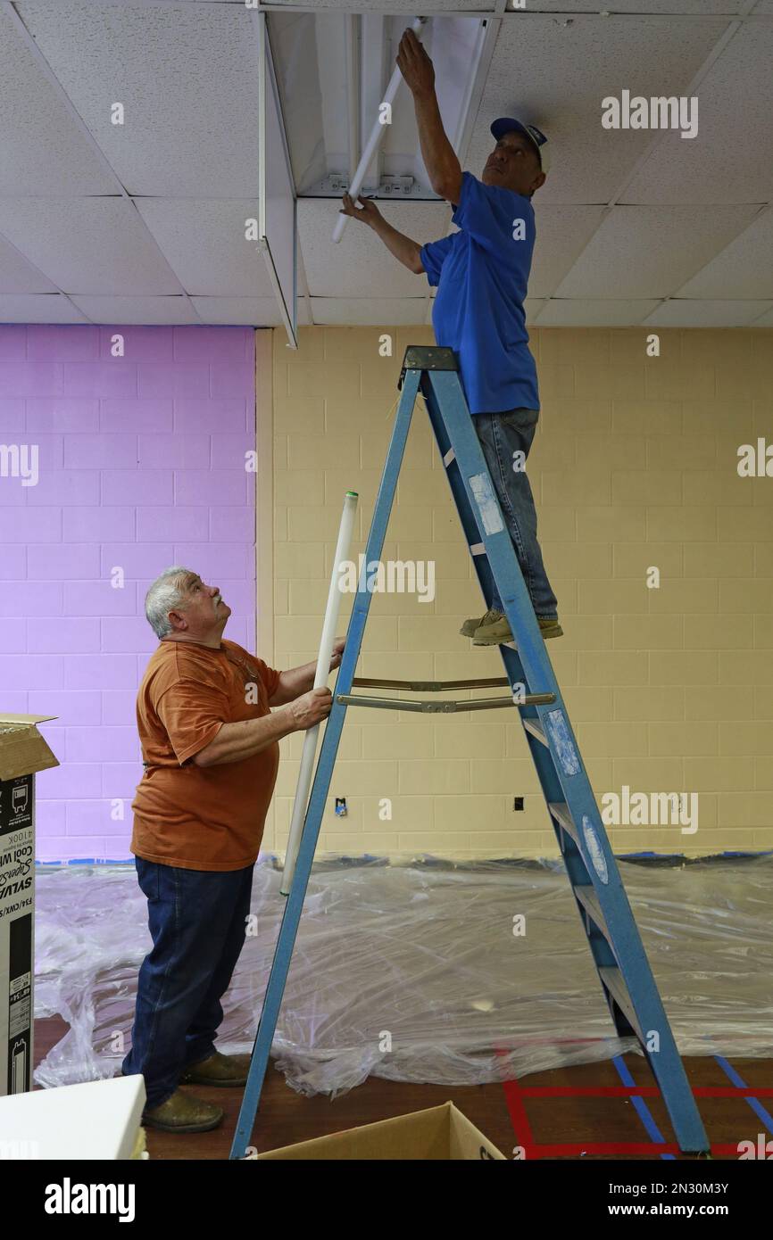 Larry Zamora, from the left, and Carlos Garcia work on lighting as ...