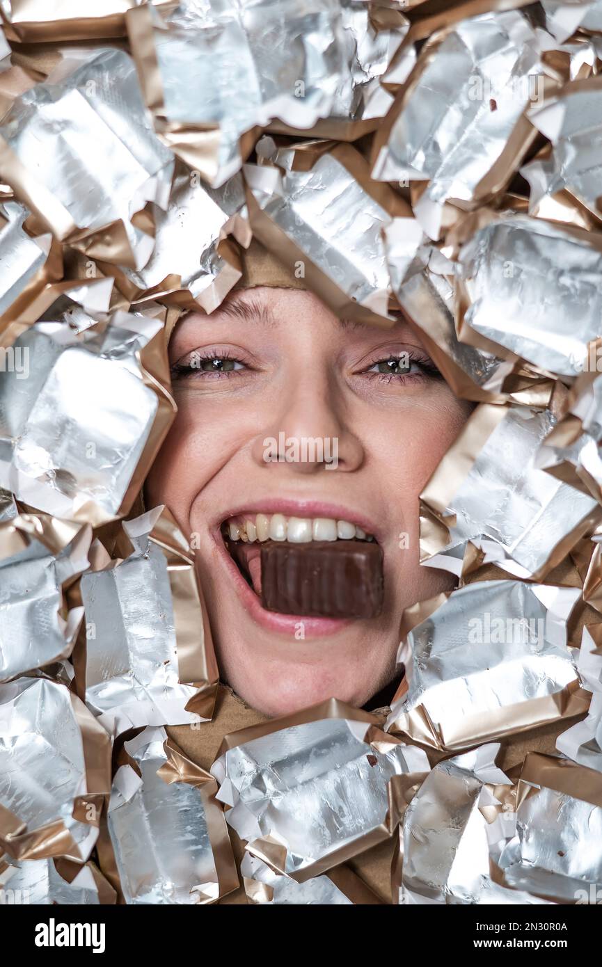 The face of a Caucasian woman surrounded by candy wrappers. The girl ...