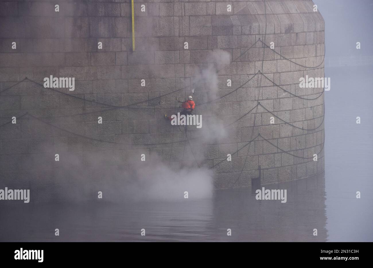 London, England, UK. 7th Feb, 2023. A worker steam-cleans Tower Bridge ...