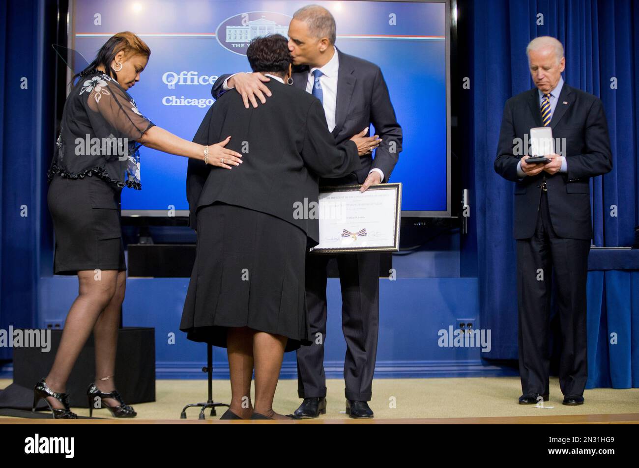 Attorney General Eric Holder embraces Maxine Hooks, center, mother of ...